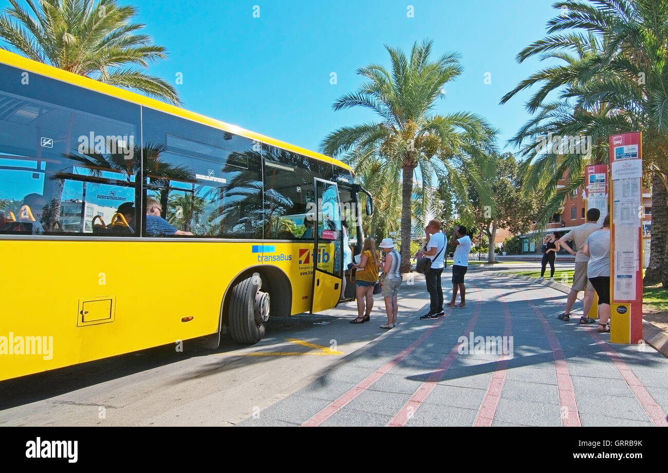 Passengers board a yellow regional bus TIB at a bus stop on a sunny day ...