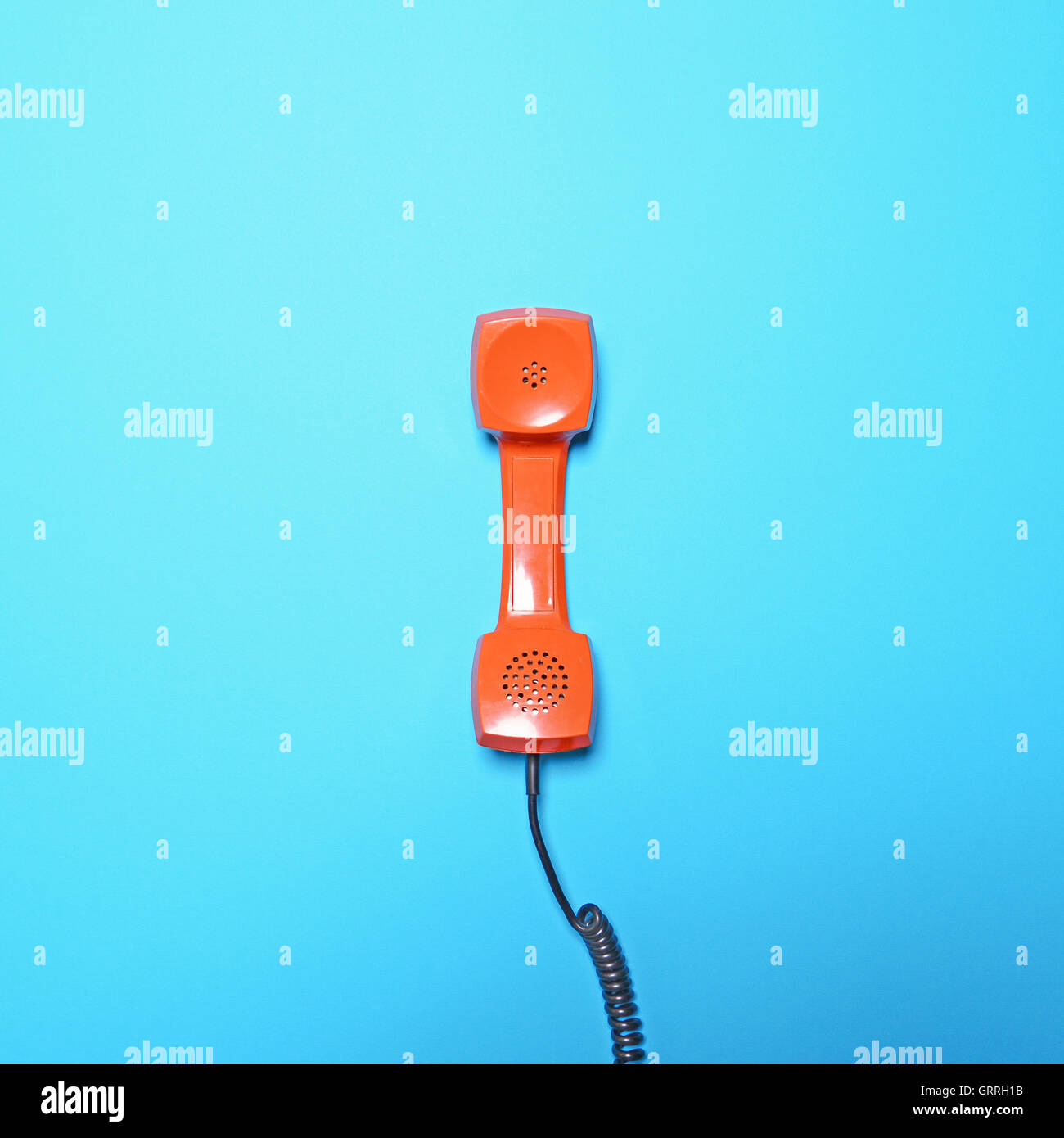 Retro orange telephone tube on blue background - Flat lay Stock Photo ...