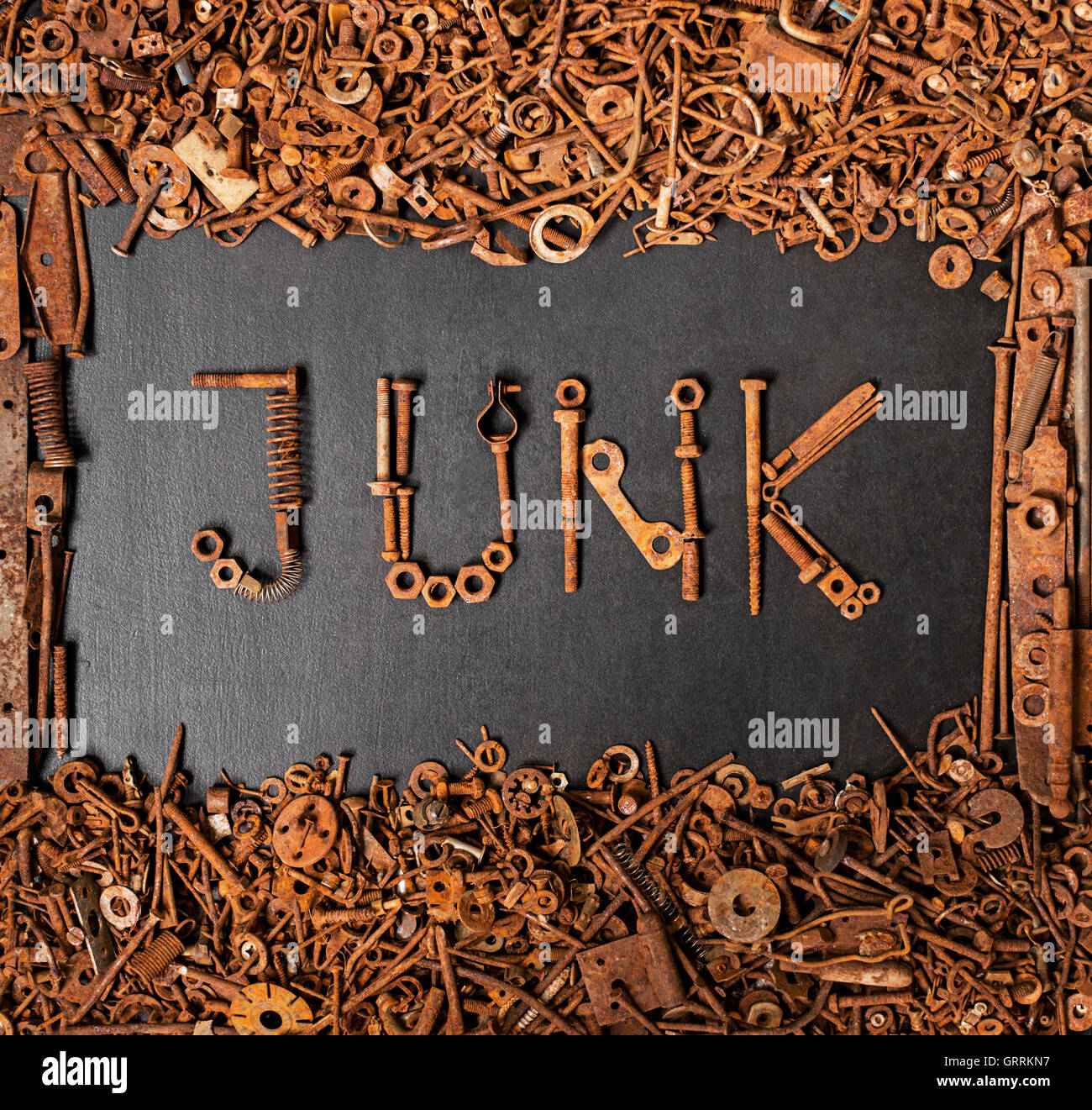 JUNK made with rusty screws and bolts on black board with frame ...