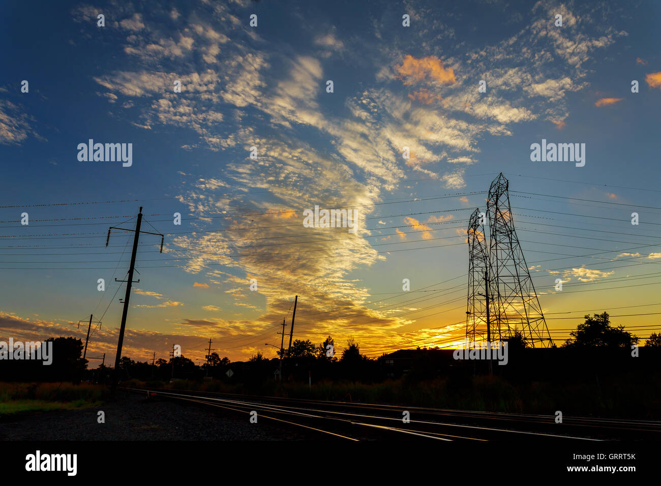 Cargo train platform at sunset. High voltage power pylons in sunset ...