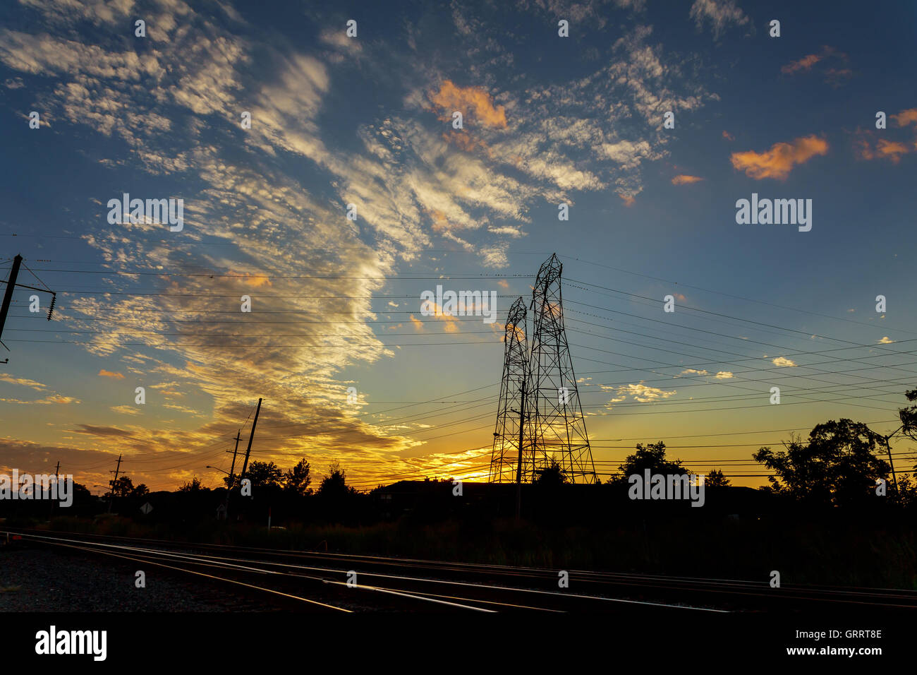 Cargo train platform at sunset. High voltage power pylons in sunset ...