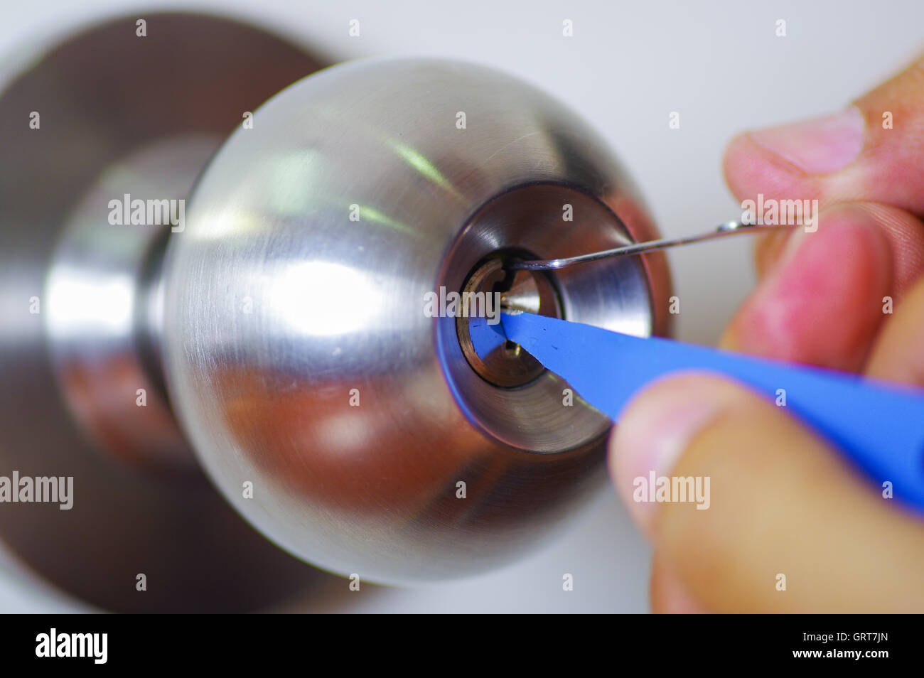 Closeup hands of locksmith using pick tools to open locked door Stock ...