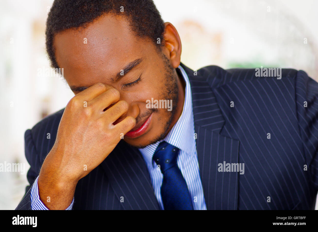 Man wearing elegant blue business suit bending head forward into ...