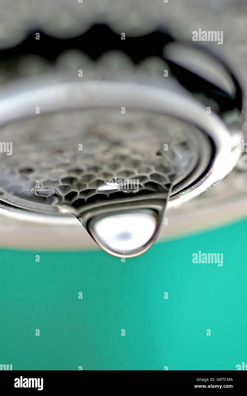 A macro of a white tap / faucet dripping with blue background Stock ...