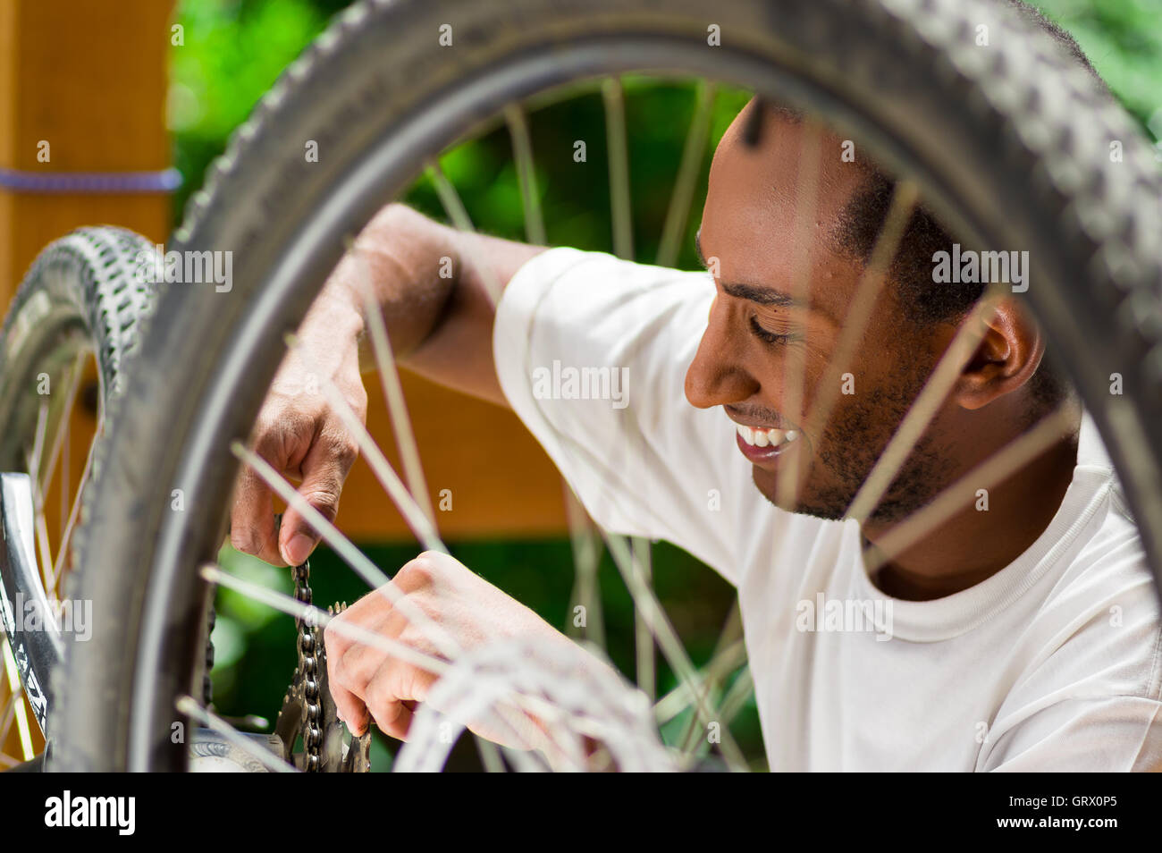 Man wearing white shirt happy working on repairing bicycle mechanics ...