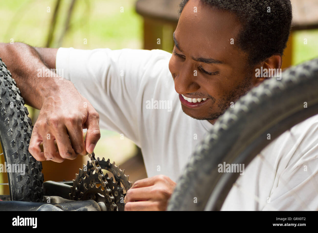 Man wearing white shirt happy working on repairing bicycle mechanics ...