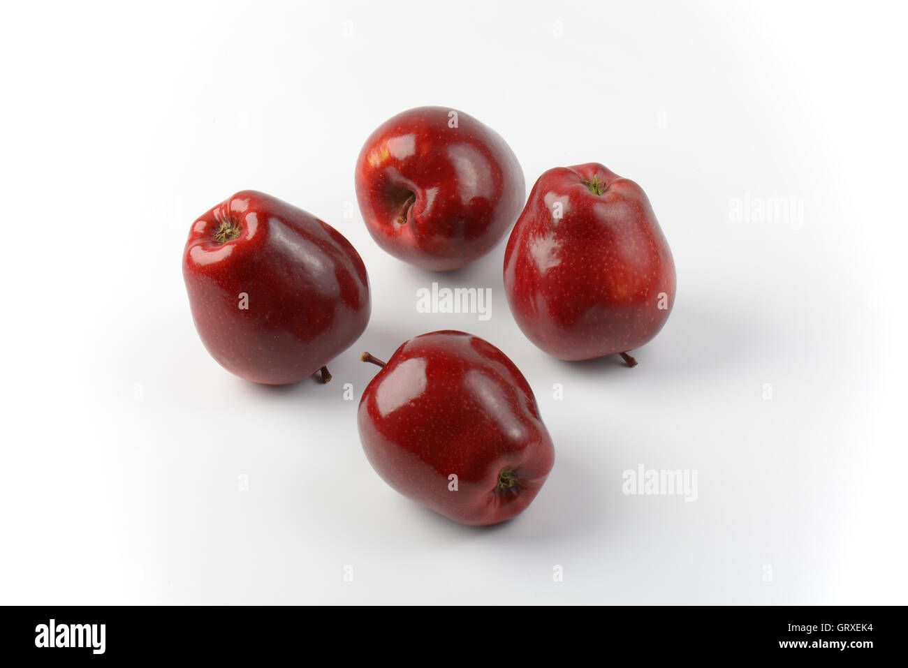 four glossy red apples on off-white background Stock Photo - Alamy
