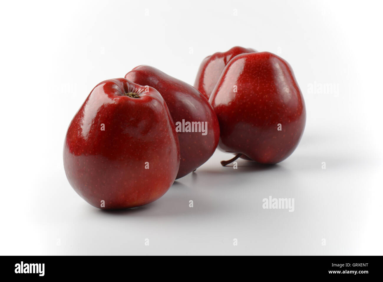 four glossy red apples on off-white background Stock Photo - Alamy