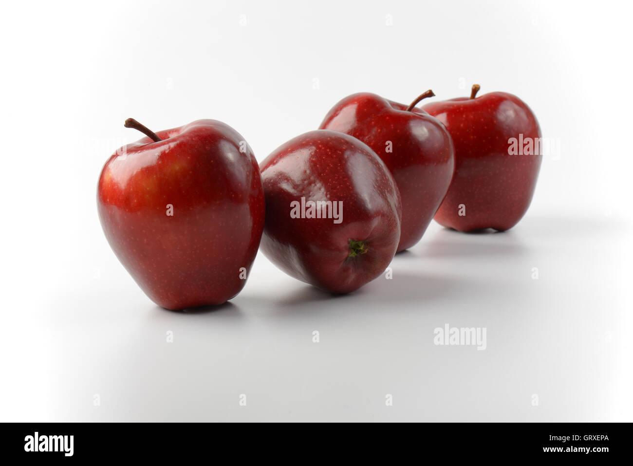 four glossy red apples in a row Stock Photo - Alamy