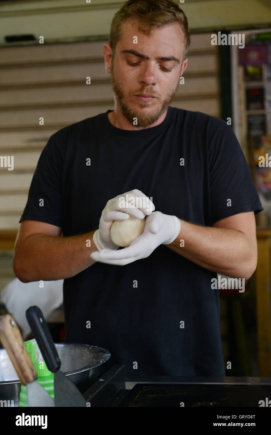 A Venezuelan man preparing arepas from maze flour in Venezuela Stock ...