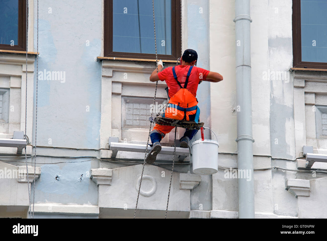 builder worker painting facade of high-rise building with rolle Stock ...