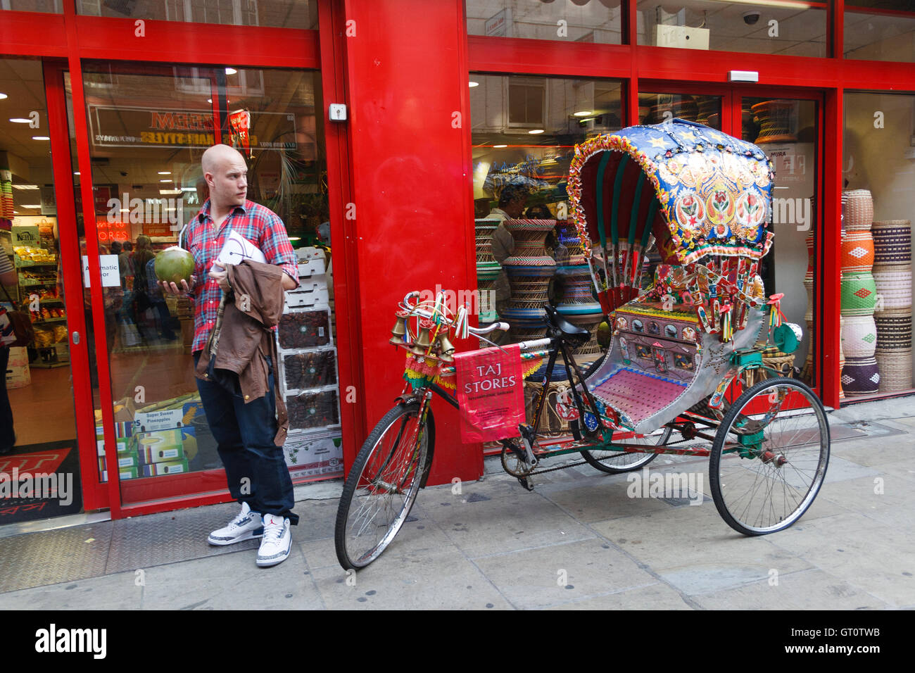 Man standing next to colourful Bengali rickshaw, Brick Lane, London, UK ...