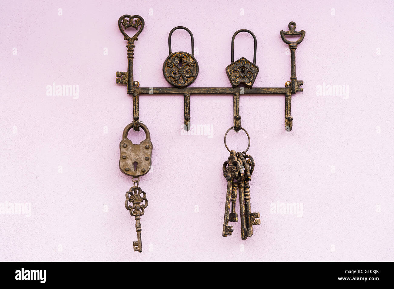 brass antique skeleton keys hanging on pink wall Stock Photo - Alamy