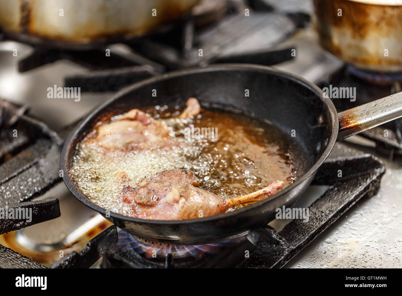 Duck legs frying in a pan Stock Photo - Alamy