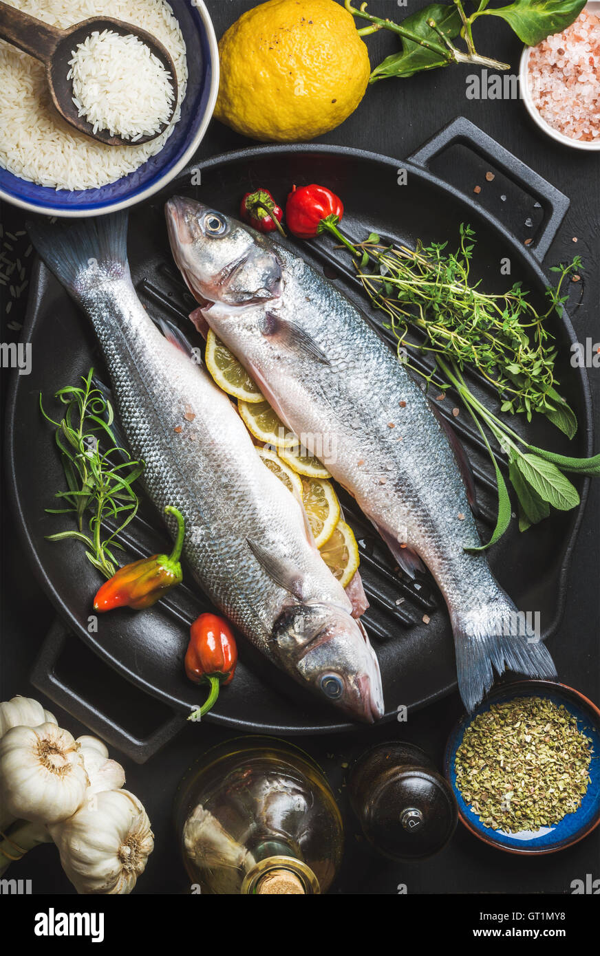 Ingredients for cooking healthy fish dinner. Raw uncooked seabass with ...