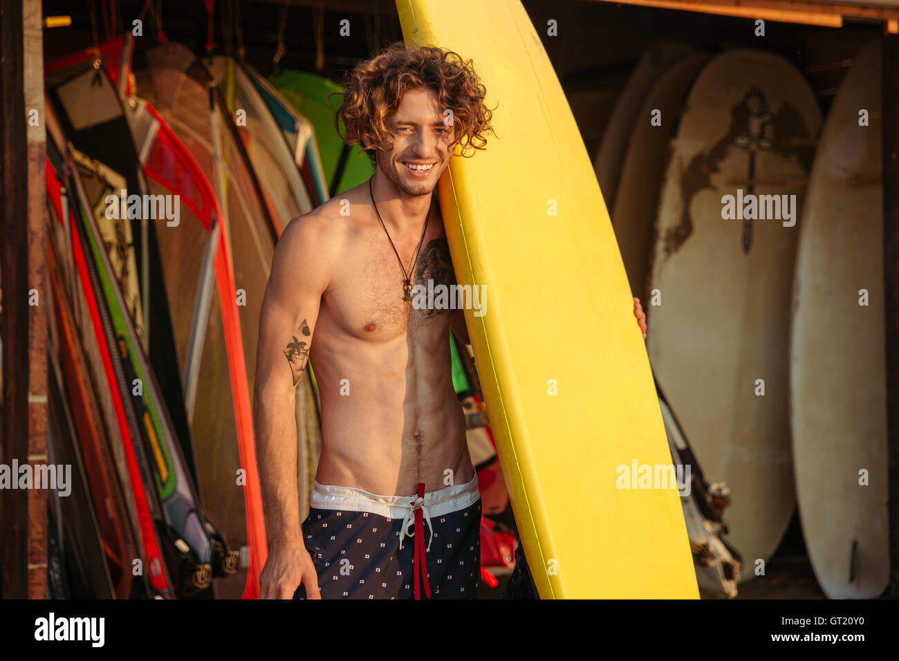 Portrait of a young curly surfer with surfboard Stock Photo - Alamy
