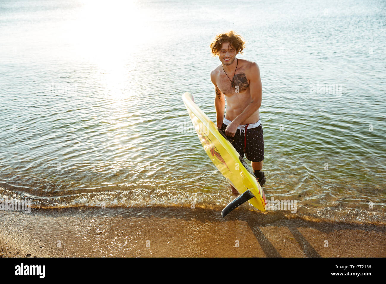 Handsome man standing surfing board hi-res stock photography and images ...