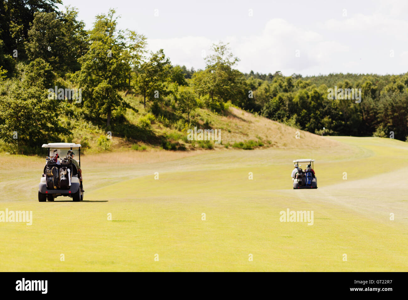 Golf carts on field by trees Stock Photo - Alamy