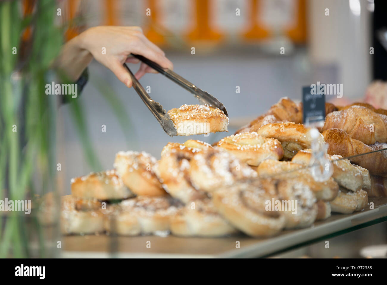 Vendor serving sweet bun with tongs Stock Photo - Alamy