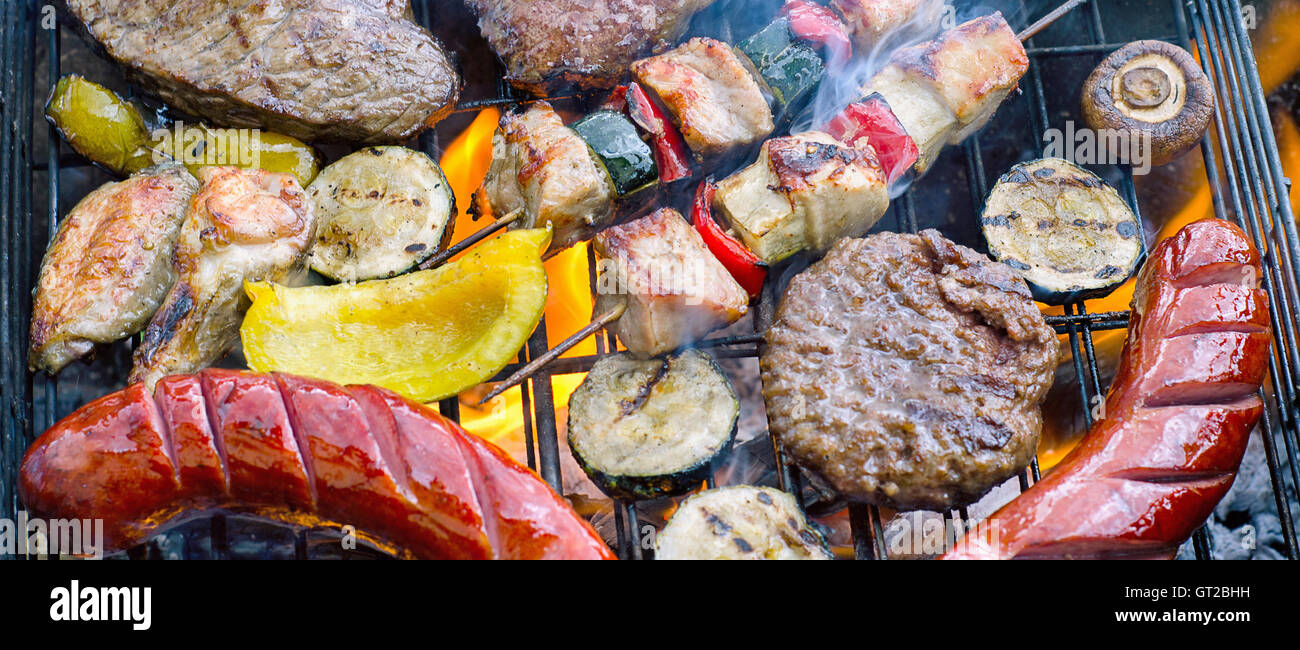Assorted meat with vegetables cooking on a grill with flames Stock ... Assorted meat with vegetables cooking on a grill with flames Stock ...