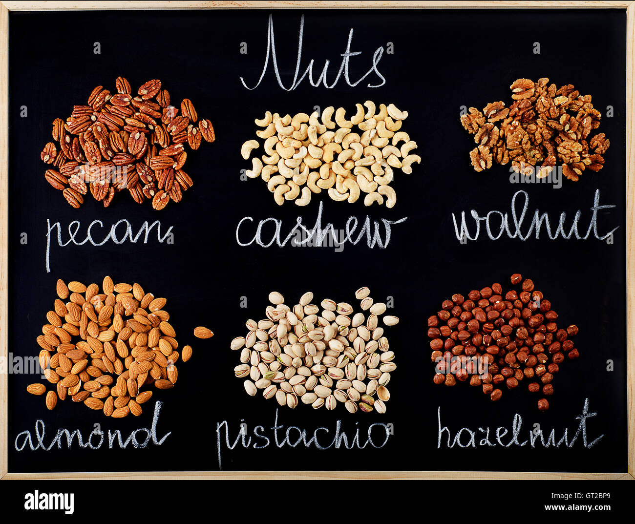 Different types of nuts on black background. Top view Stock Photo - Alamy