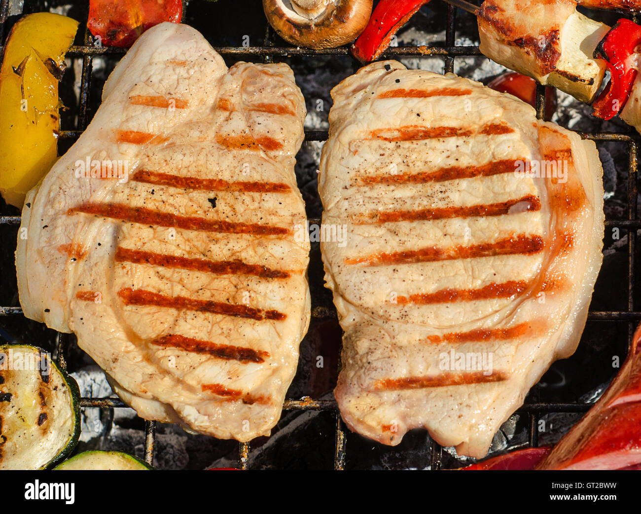 Roasted pork chops and kebabs with vegetables. Top view Stock Photo - Alamy