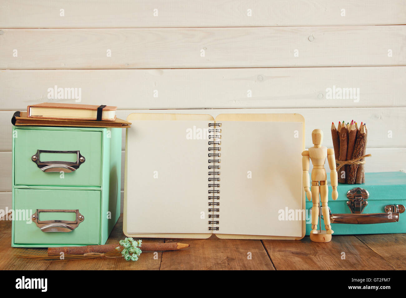 Artist supplies on wooden table: wooden drawing model, colorful pencils ...