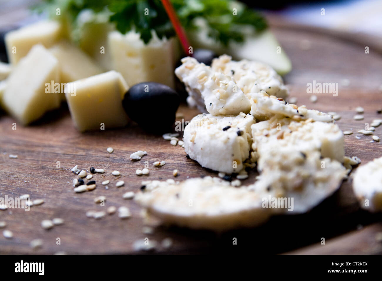 Splitting a solid tasty goat cheese with sesame seeds and herbs Stock ...