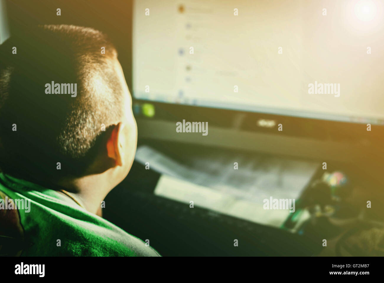 The boy was sitting at the computer screen Stock Photo - Alamy