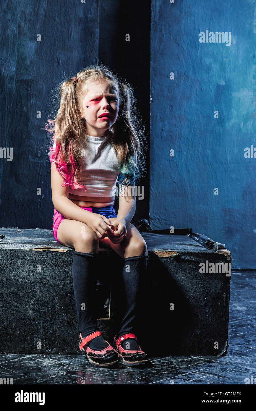 The crying crasy girl with grimace on black background Stock Photo - Alamy