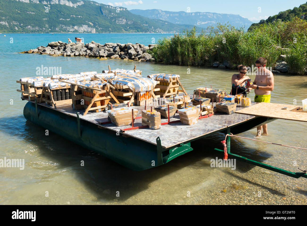 Expert couple set up & prepare beach fireworks show display on pontoon ...