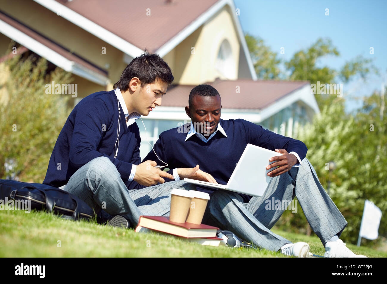 University students talking at campus grass hi-res stock photography ...