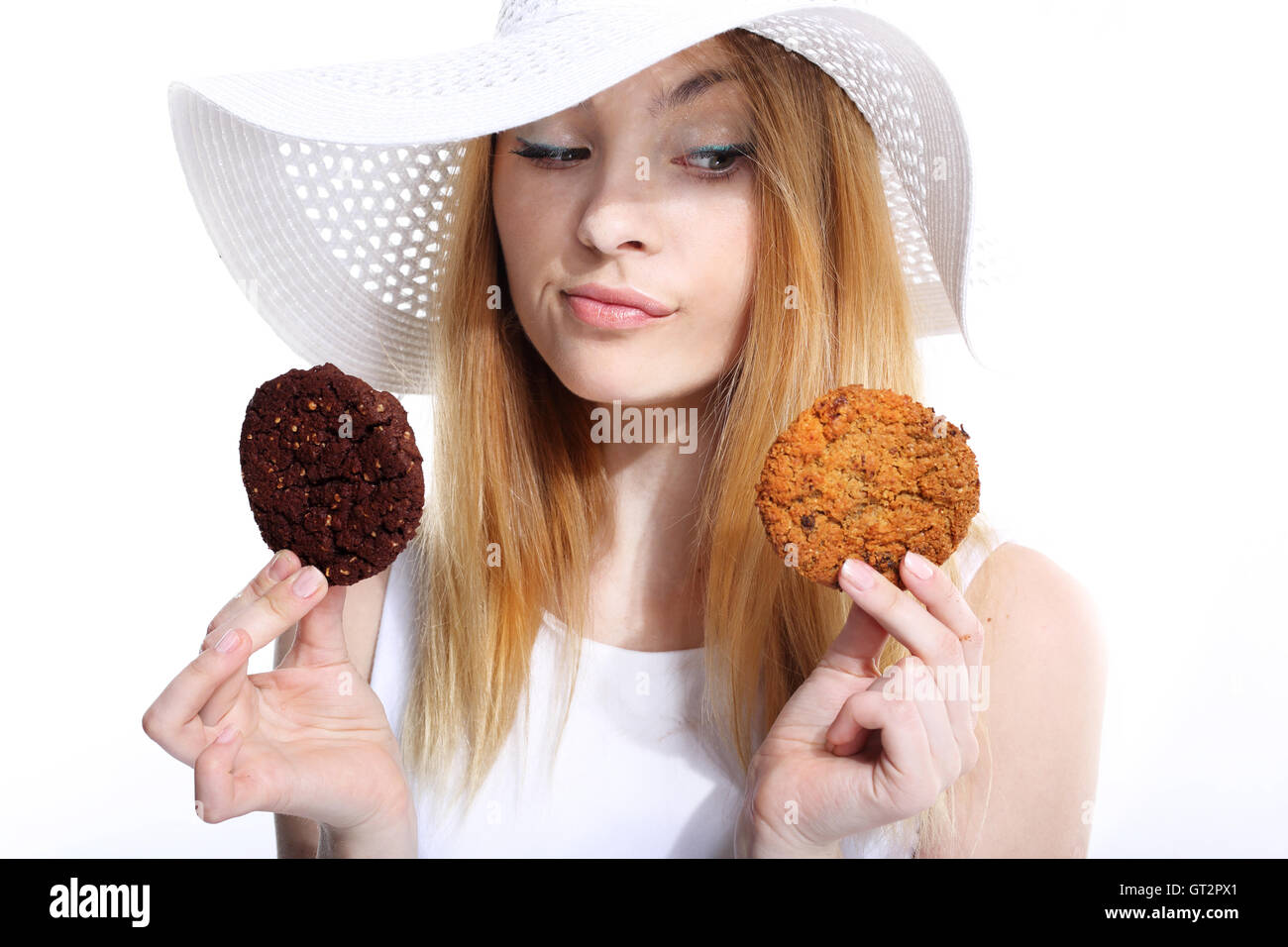 Cute young woman eats cookies on the white background Stock Photo - Alamy