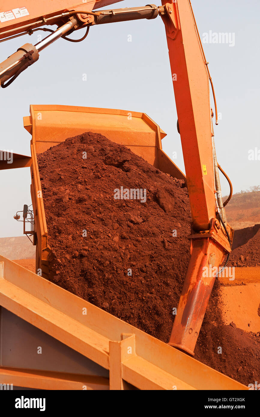Tipping of lump iron ore from mine dump truck into crusher plant hopper ...