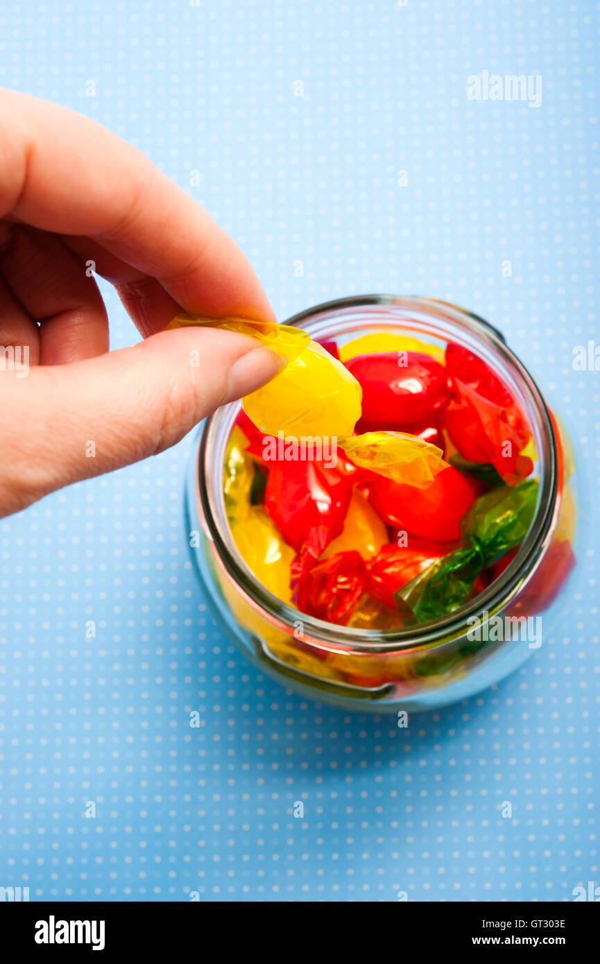 hand picking a candy from a glass jar Stock Photo - Alamy