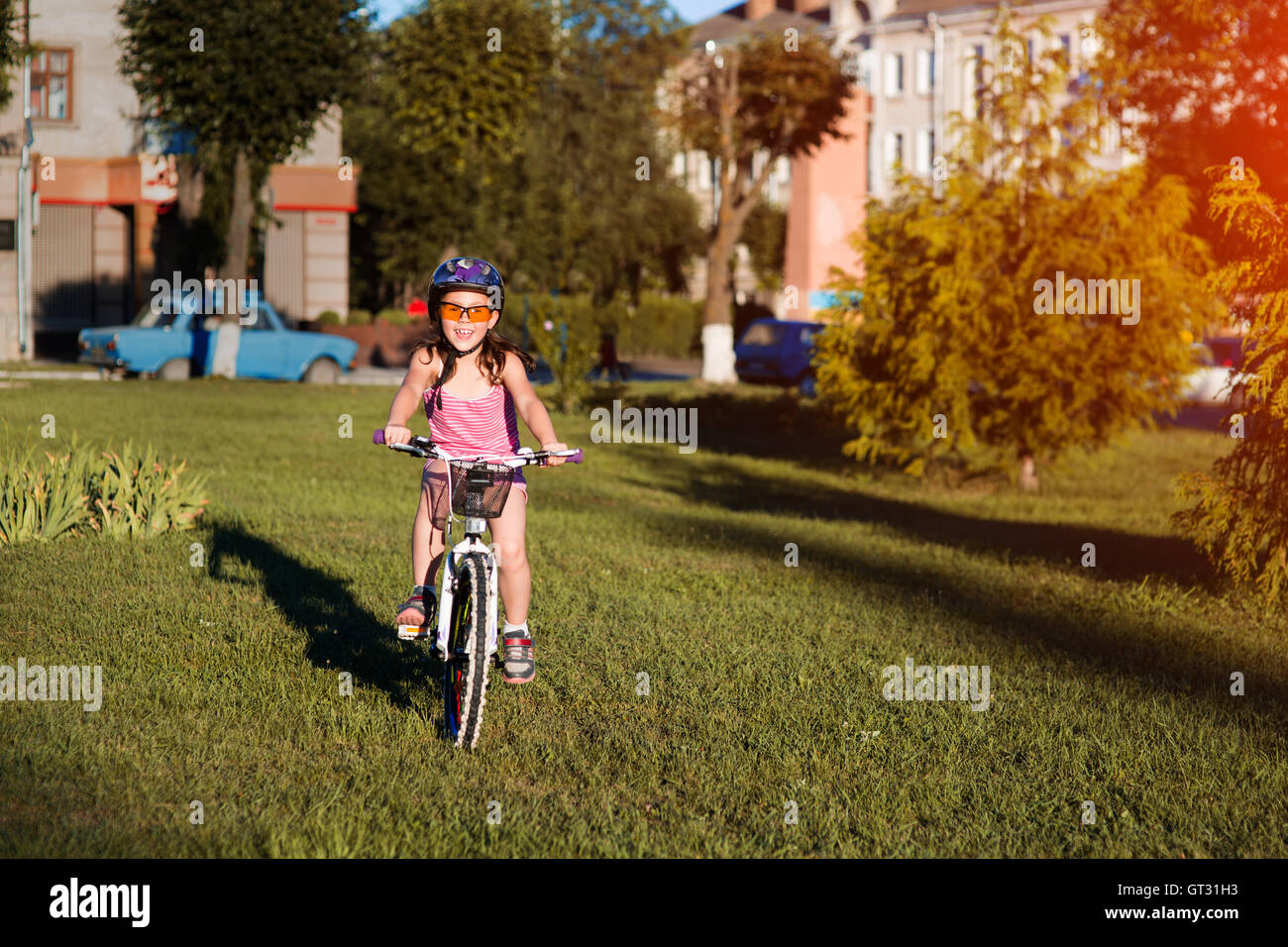 child girl riding bicycle on summer sunset in the park Stock Photo - Alamy
