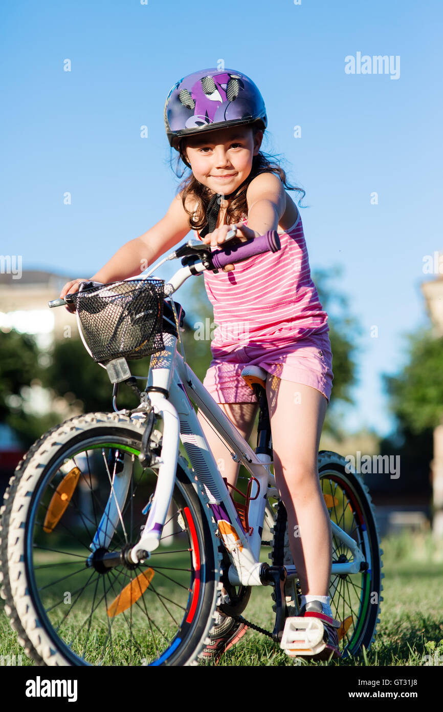 child girl riding bicycle on summer sunset in the park Stock Photo - Alamy
