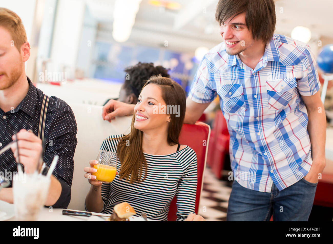 Friends eating fast food at the table in the diner Stock Photo - Alamy