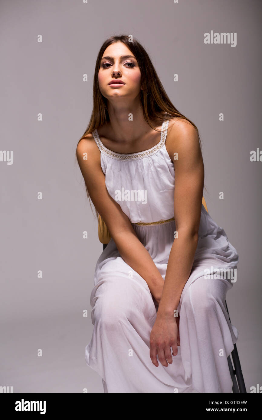 Pretty Young Woman With Long Hair In White Dress In Studio Stock Photo
