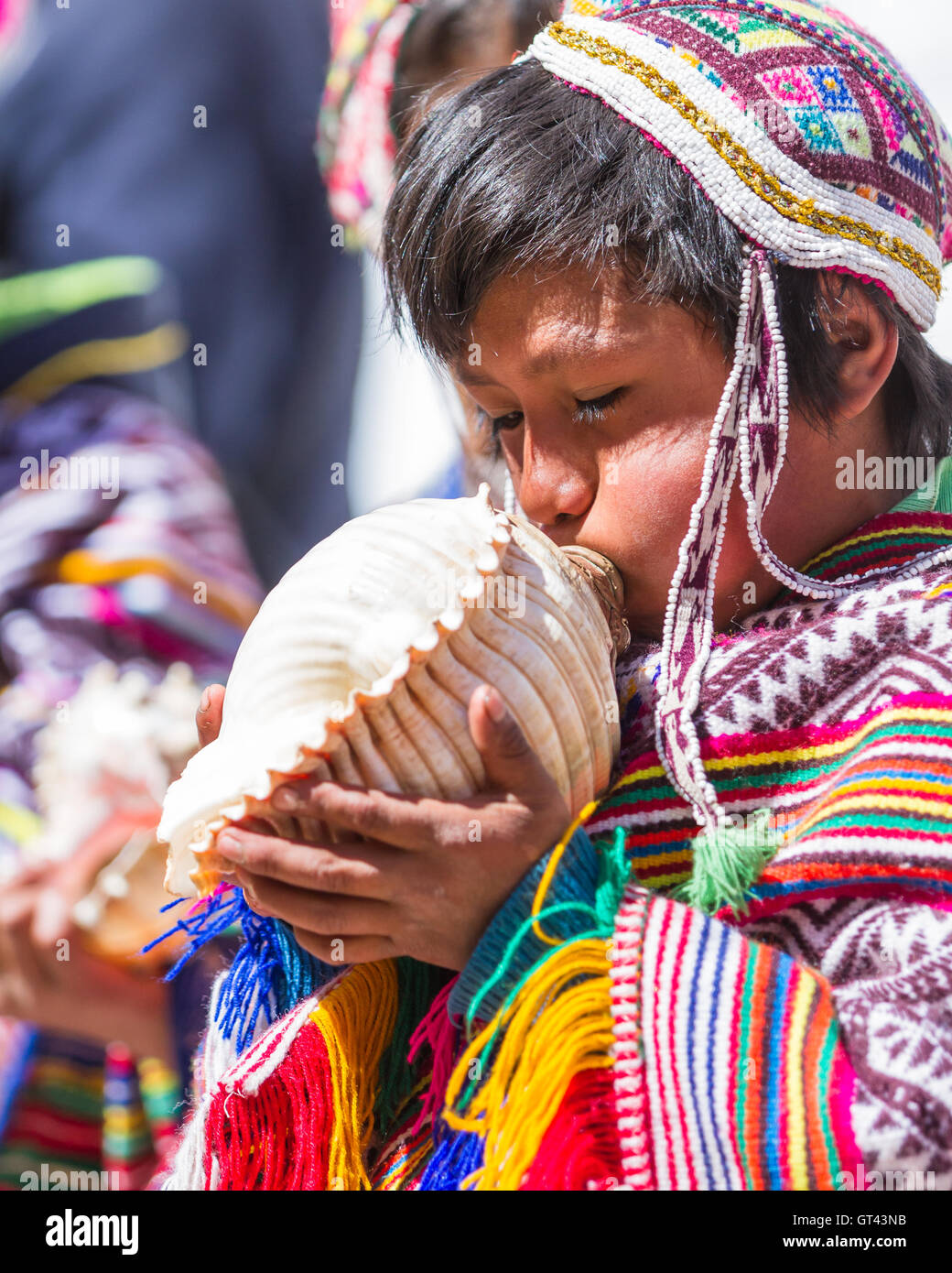 Pisac, Peru - May 15: Young man playing a tune using a conch shell as ...