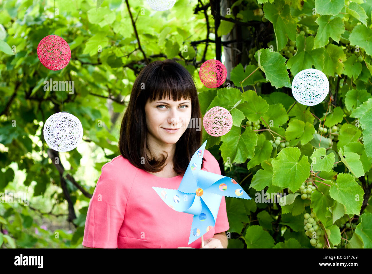 Beautiful girl laughing and holding a windmill Stock Photo - Alamy
