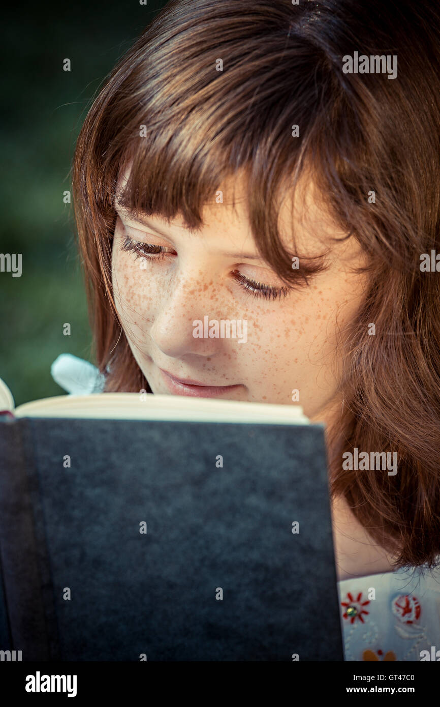 Student beautiful girl reading a book outdoor Stock Photo - Alamy