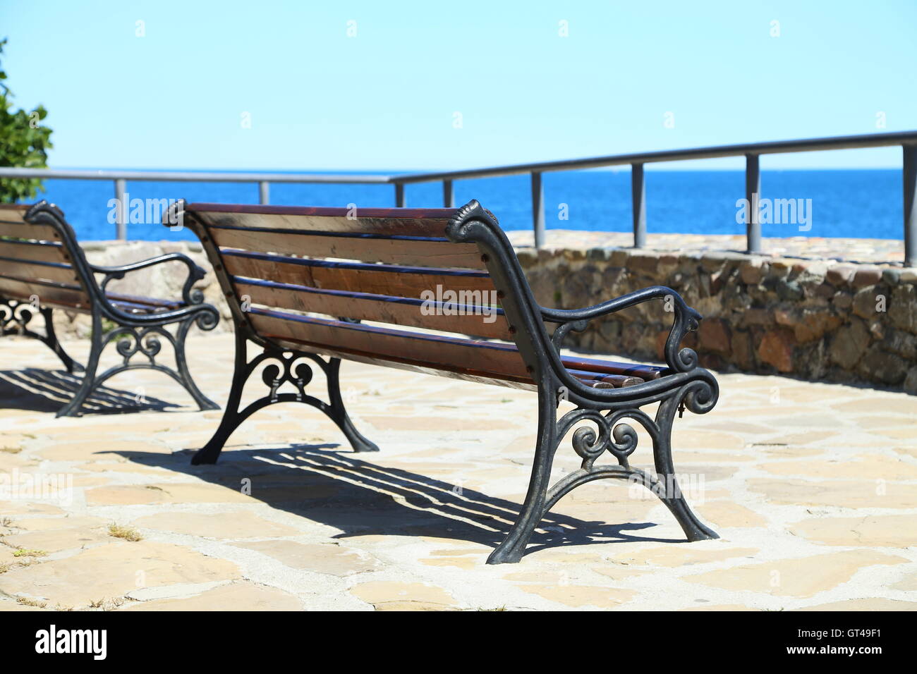 Wrought-iron bench on a stone seafront Stock Photo - Alamy