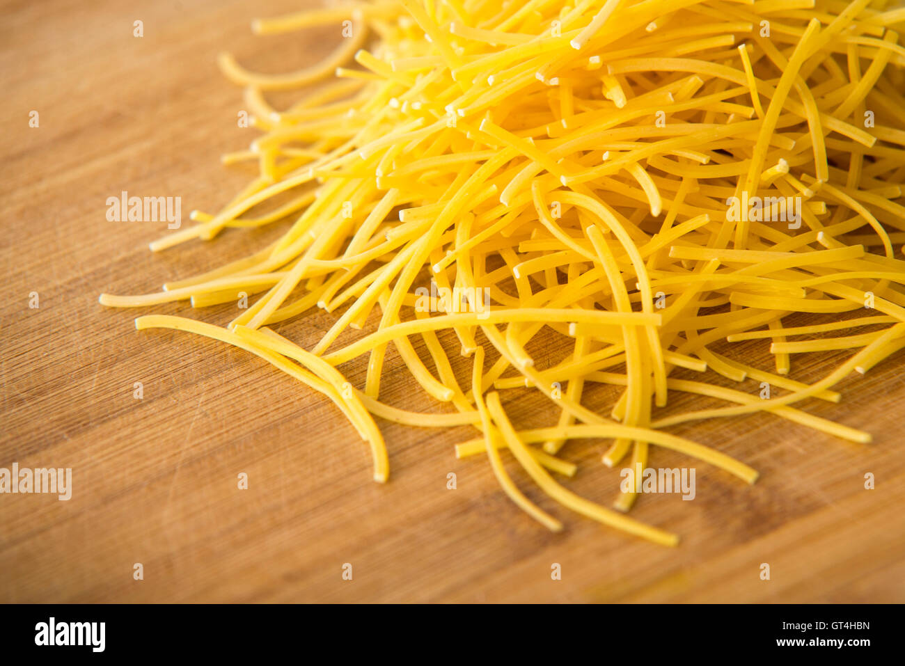 Small dry pasta noodles on wood background Stock Photo - Alamy