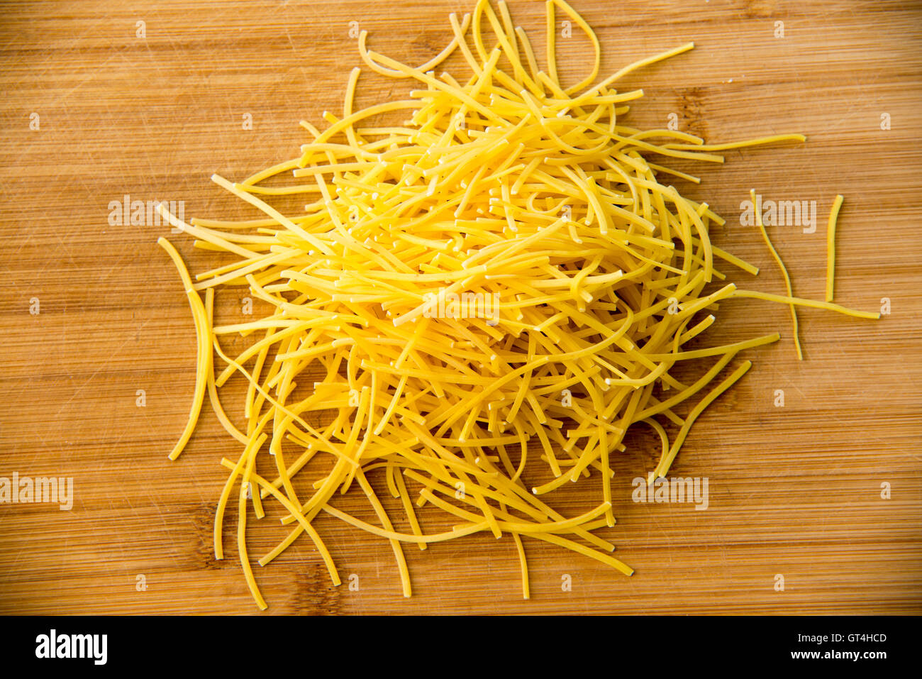 Small dry pasta noodles on wood background Stock Photo - Alamy