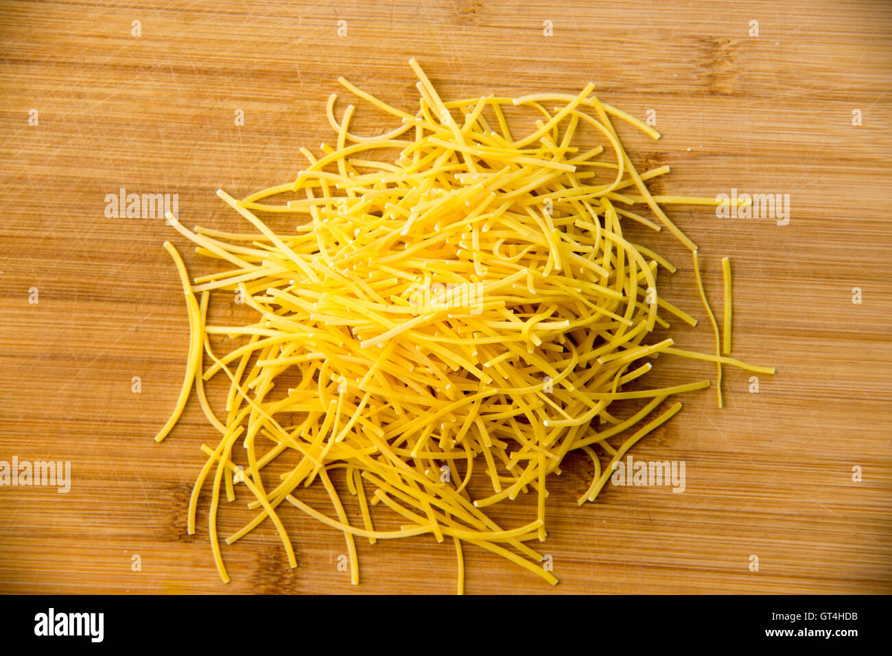 Small dry pasta noodles on wood background Stock Photo - Alamy