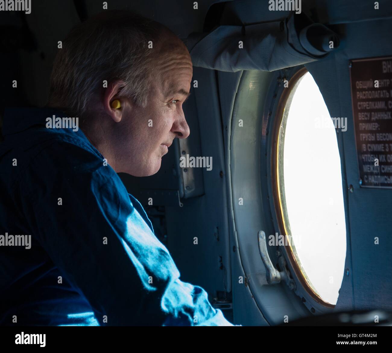 NASA astronaut Jeff Williams looks out the window of Russian MI-8 ...