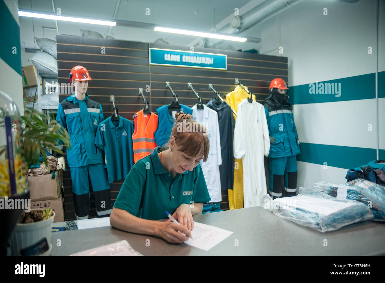 Smiling storekeeper of SIBUR company gives uniform Stock Photo - Alamy