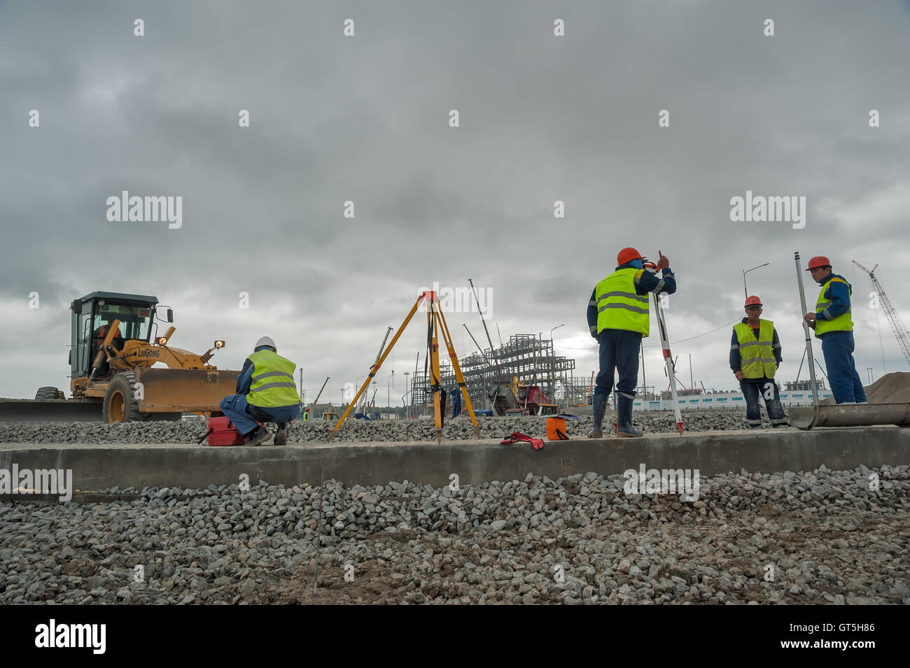Workers do base under big oil tank Stock Photo - Alamy