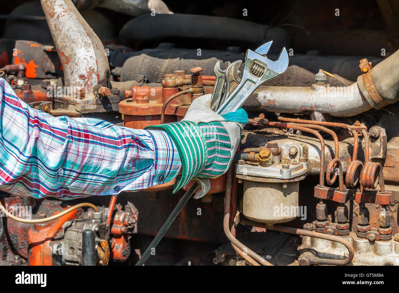 Man's hand with adjustable wrench near old diesel engine Stock Photo ...